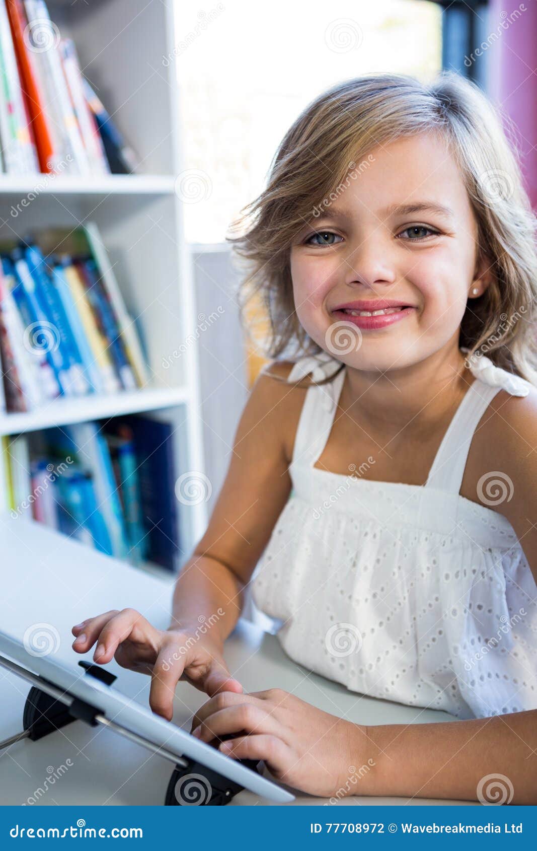 Smiling Girl Using Digital Tablet in School Library Stock Photo - Image ...