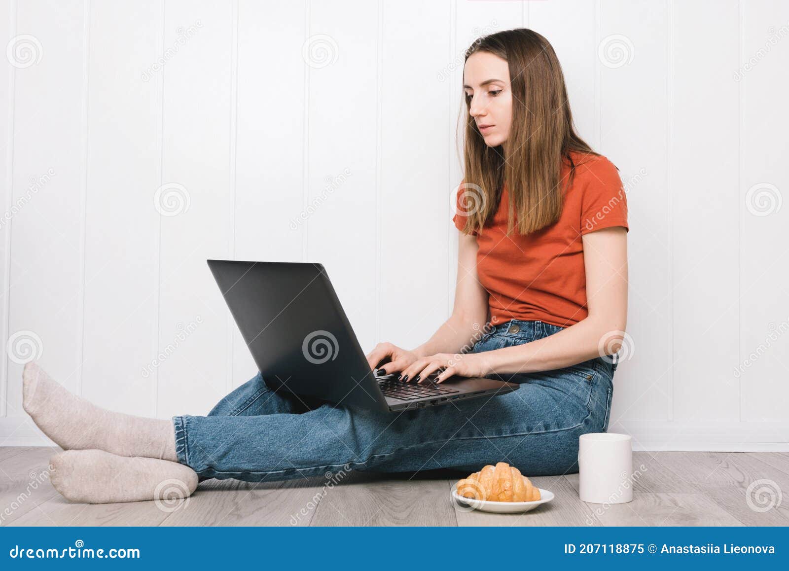 Smiling Girl Working on Laptop Computer while Sitting on a Floor with ...