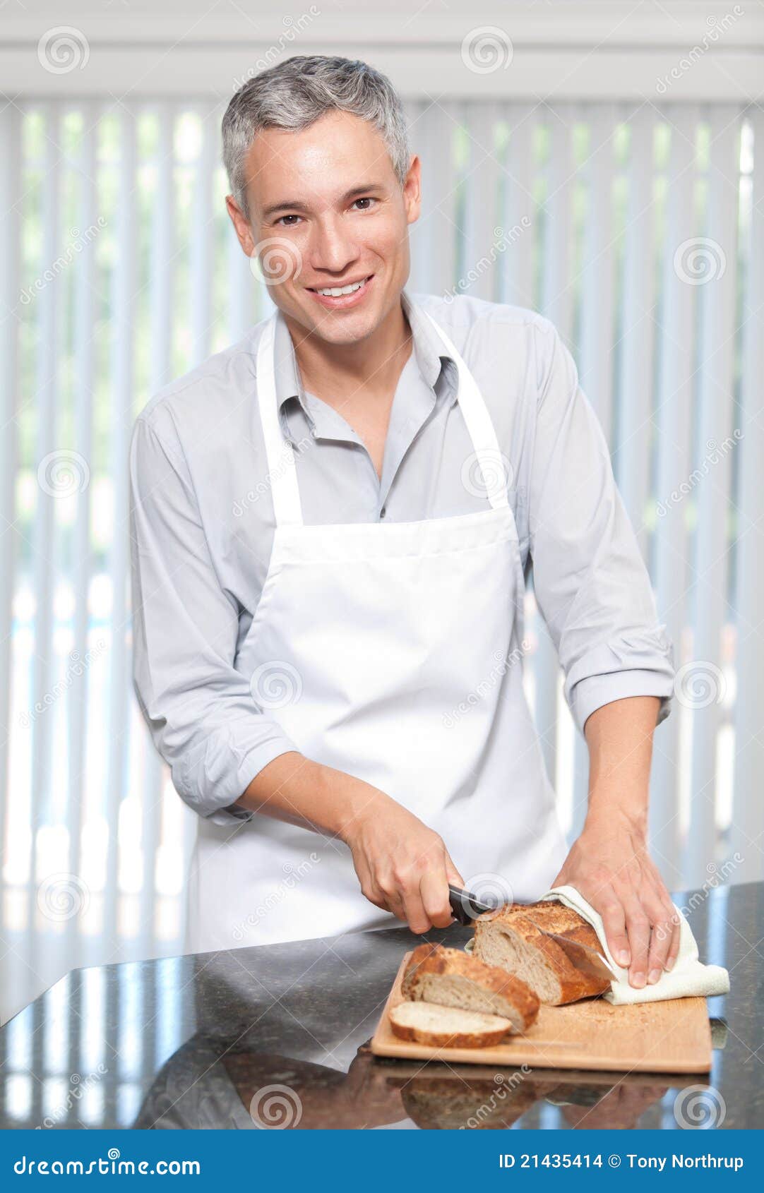 Smiling Grey Hair Man Cutting Bread in Apron Stock Photo - Image of ...