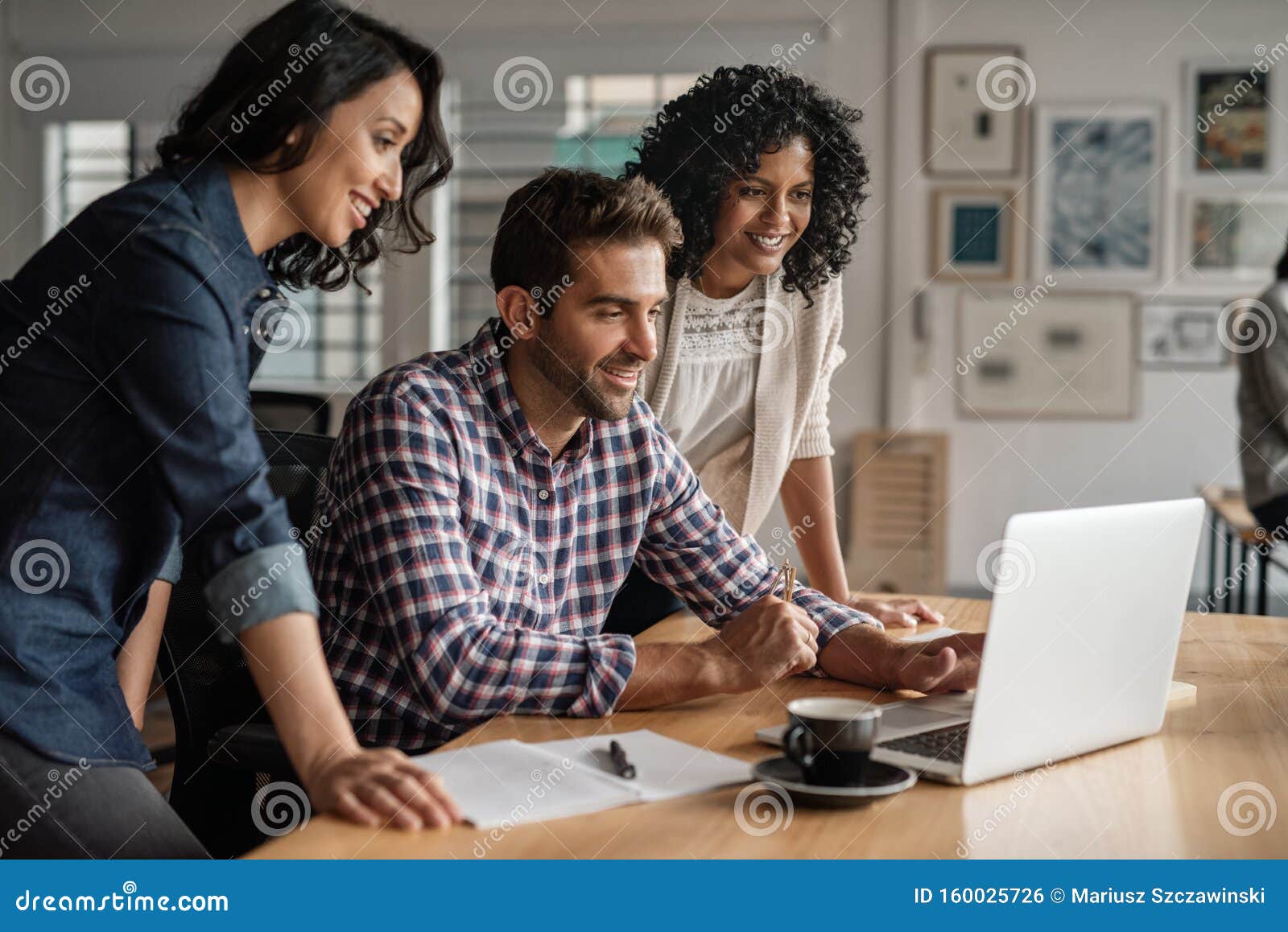 Smiling Group of Designers Working Together on an Office Laptop Stock ... Smiling Group of Designers Working Together on an Office Laptop Stock ...