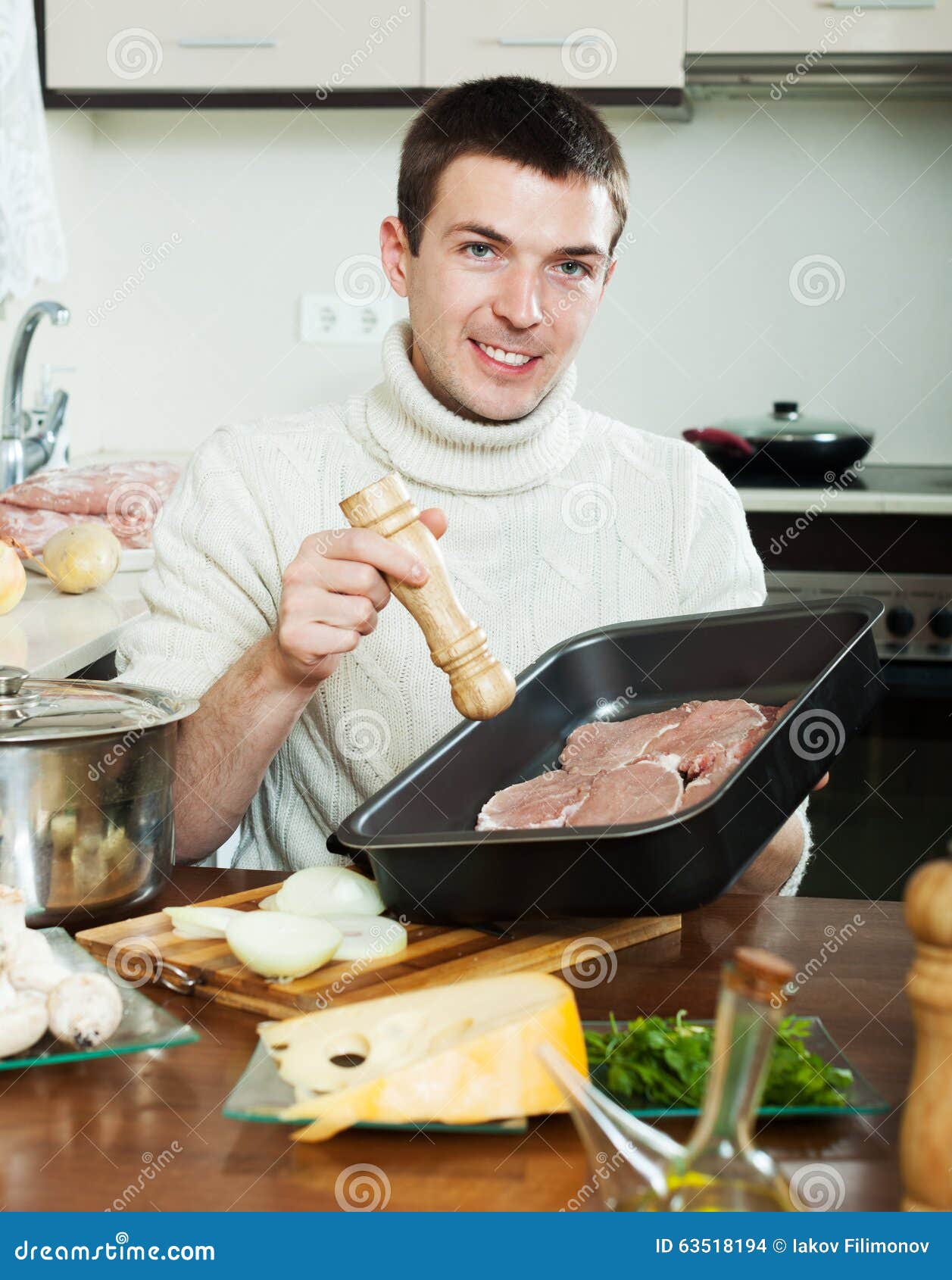 Smiling guy cooking meat stock photo. Image of caucasian - 63518194