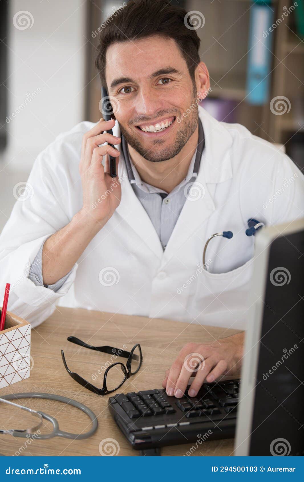 Smiling Handsome Doctor Using Computer and Smartphone Stock Image ...