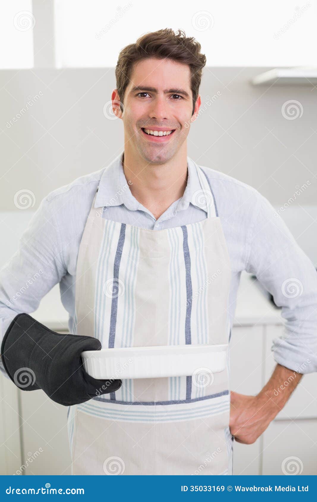 Smiling Handsome Man Holding a Baking Dish in Kitchen Stock Image ...