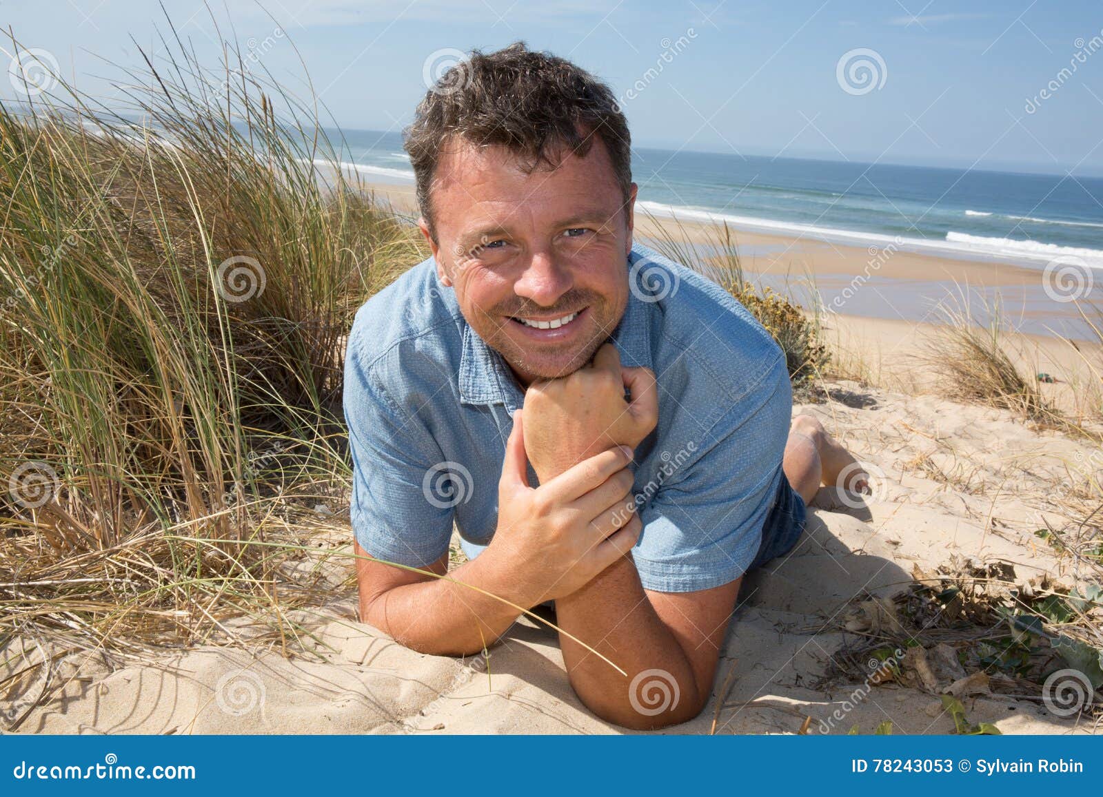 Smiling Handsome Man Relaxing on the Beach Lying on Sand Stock Image ...