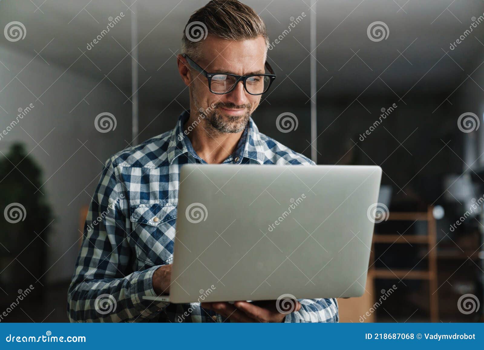 Smiling Man Working with Laptop while Standing in Office Stock Photo ...