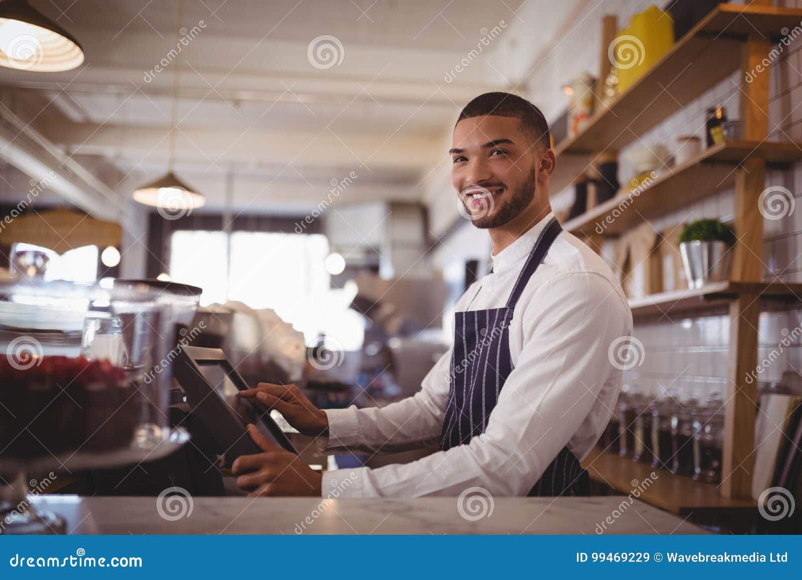 Smiling Handsome Young Waiter Using Computer at Counter Stock Image ...