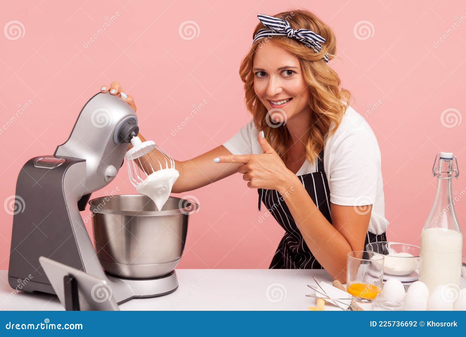 Smiling Happy Blonde Baker Making Cream with Food Processor, Looking at ...
