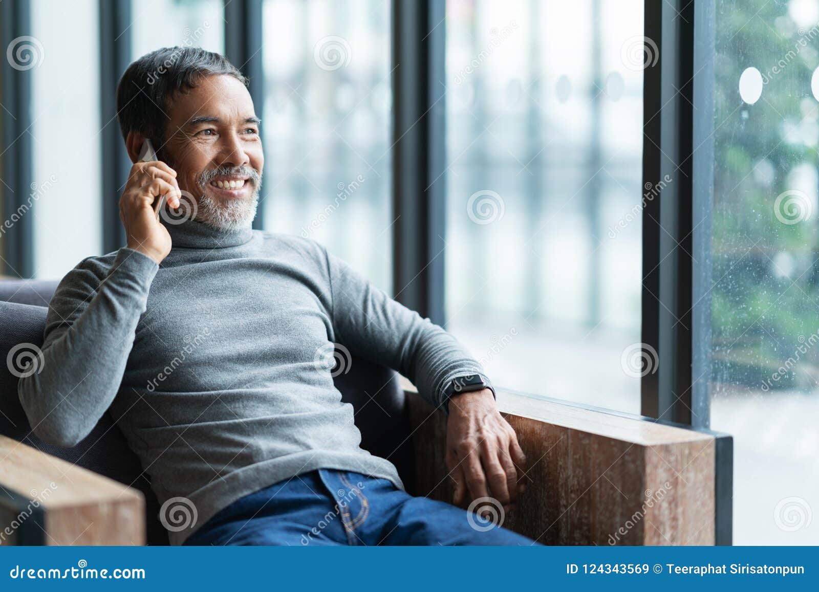 Smiling Happy Mature Asian Man With White Stylish Short Beard Using