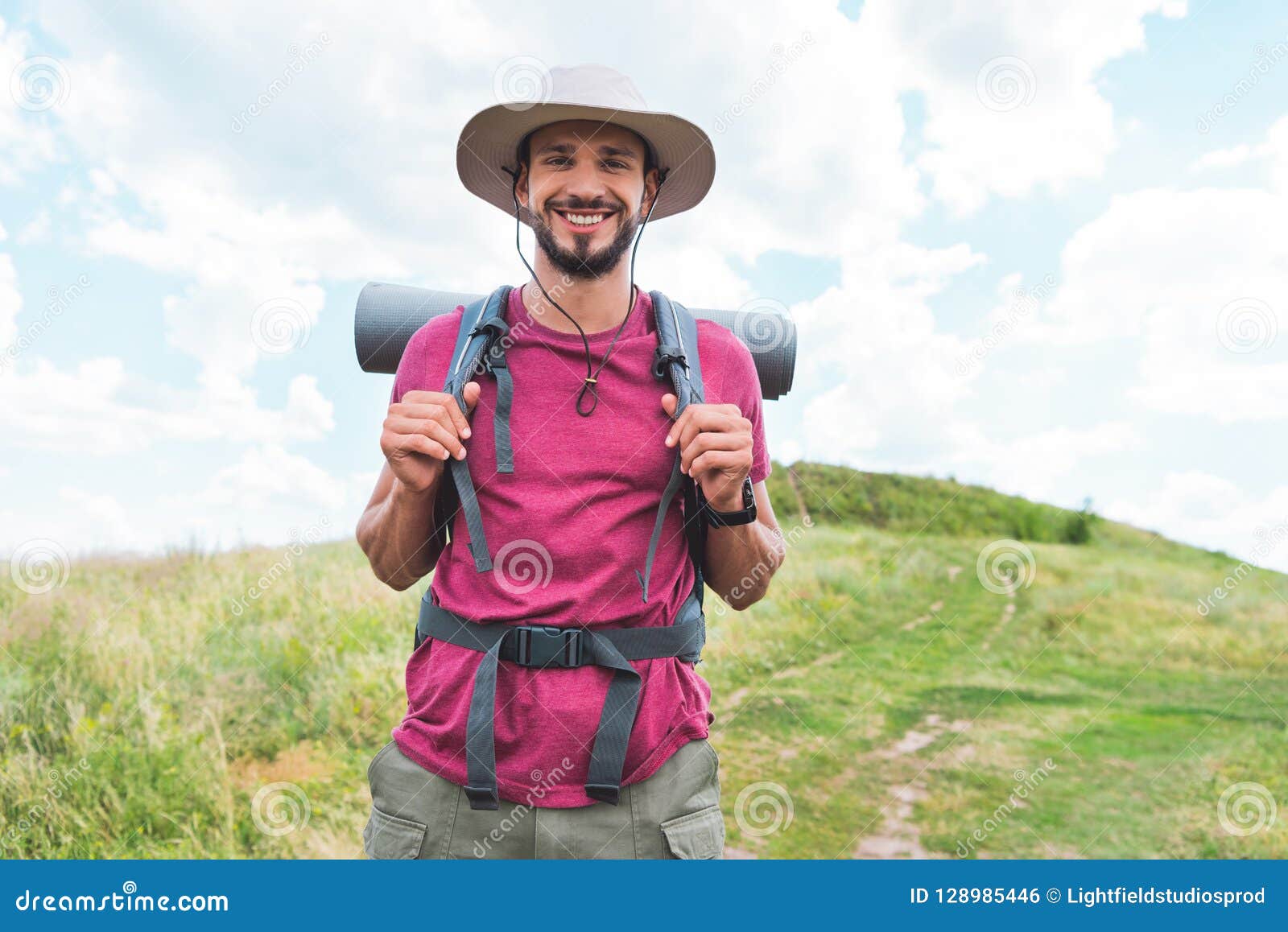 Smiling Hiker in Hat with Backpack Walking on Green Stock Photo - Image ...