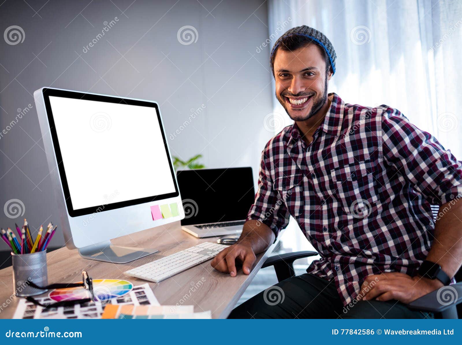 Smiling Hipster Man Posing for Camera at Computer Desk in Studio Stock ...