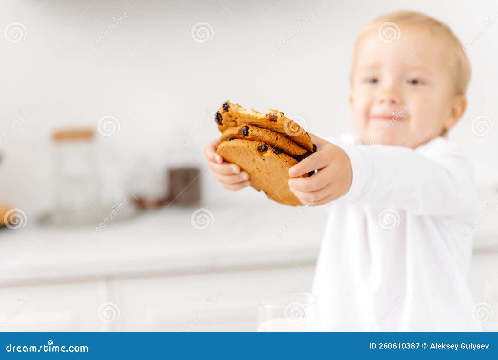 Smiling Kid Holding Out an Oatmeal Cookie. Camera Focus on the Cookie ...