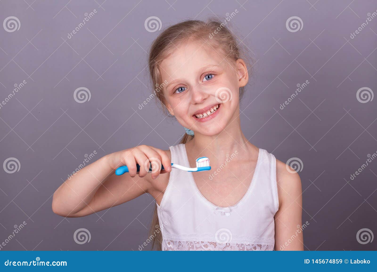 Smiling Little Girl with Tooth Paste and Brush on Gray Stock Image ...