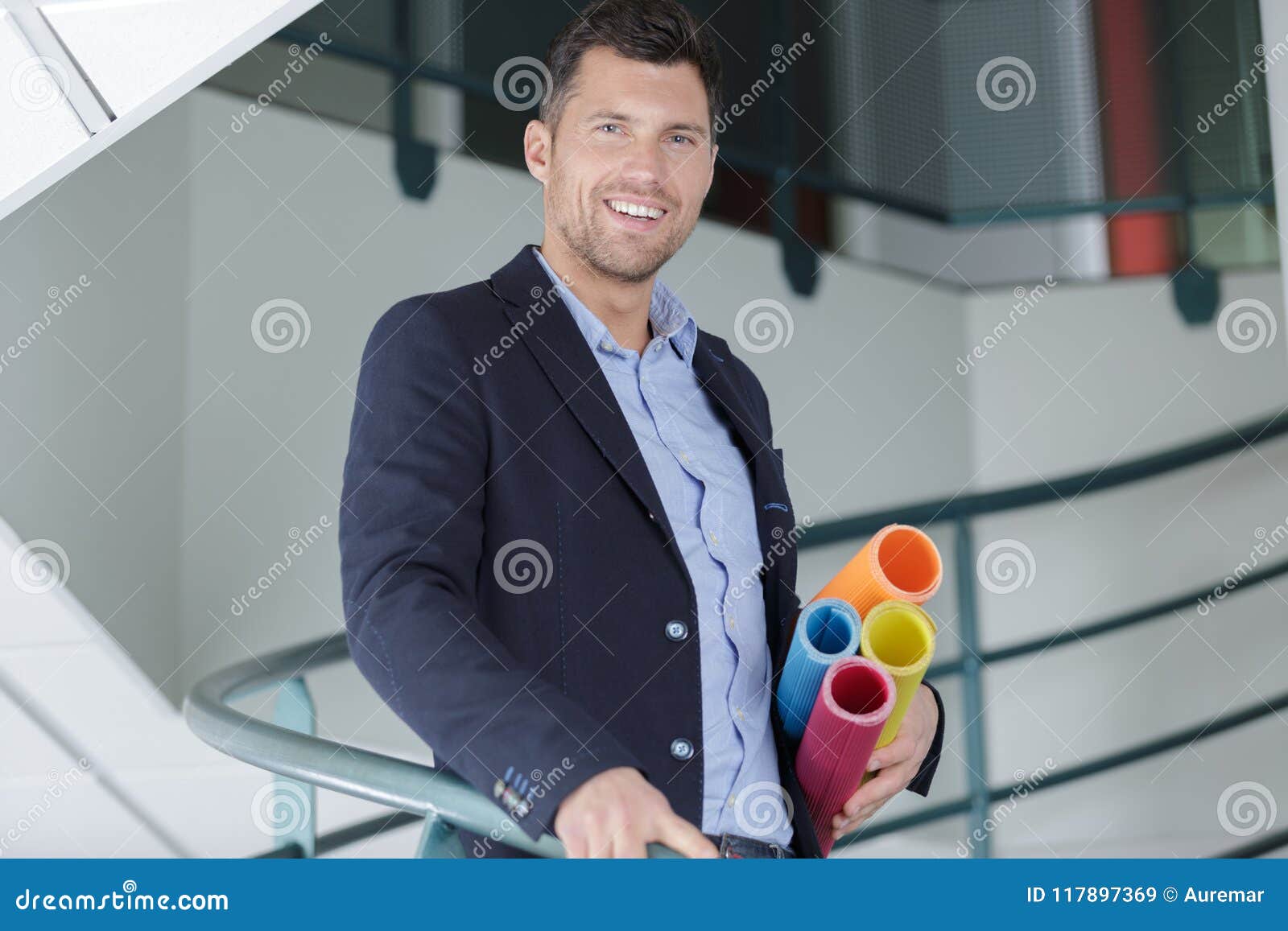 Smiling Male Architect Holding Blueprints Inside Building Stock Image ... Smiling Male Architect Holding Blueprints Inside Building Stock Image ...