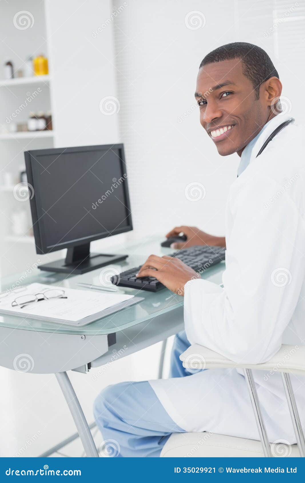 Smiling Male Doctor Using Computer at Medical Office Stock Image ...