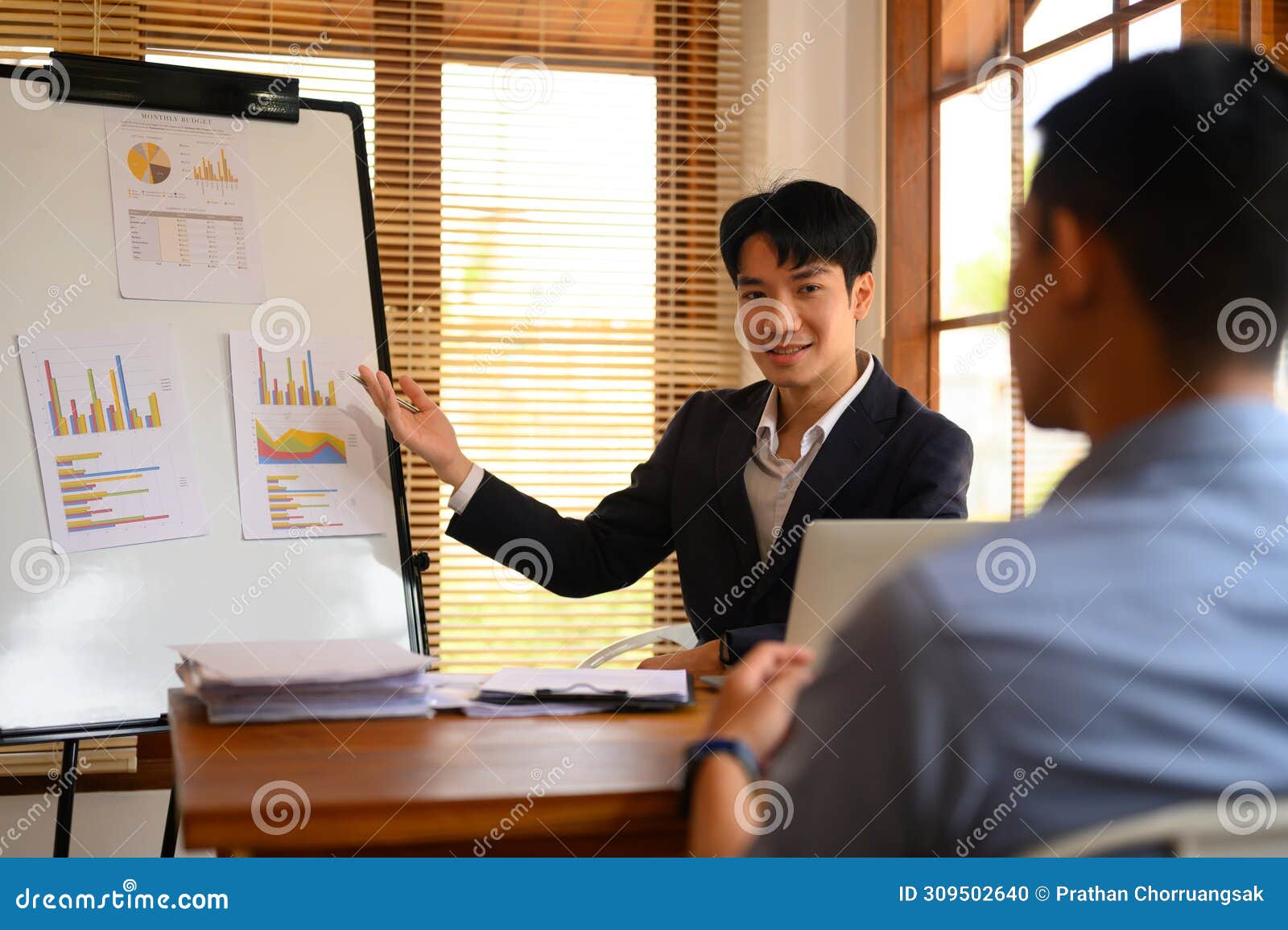 Smiling Male Manager Presenting Analysis of Financial Data on a ...