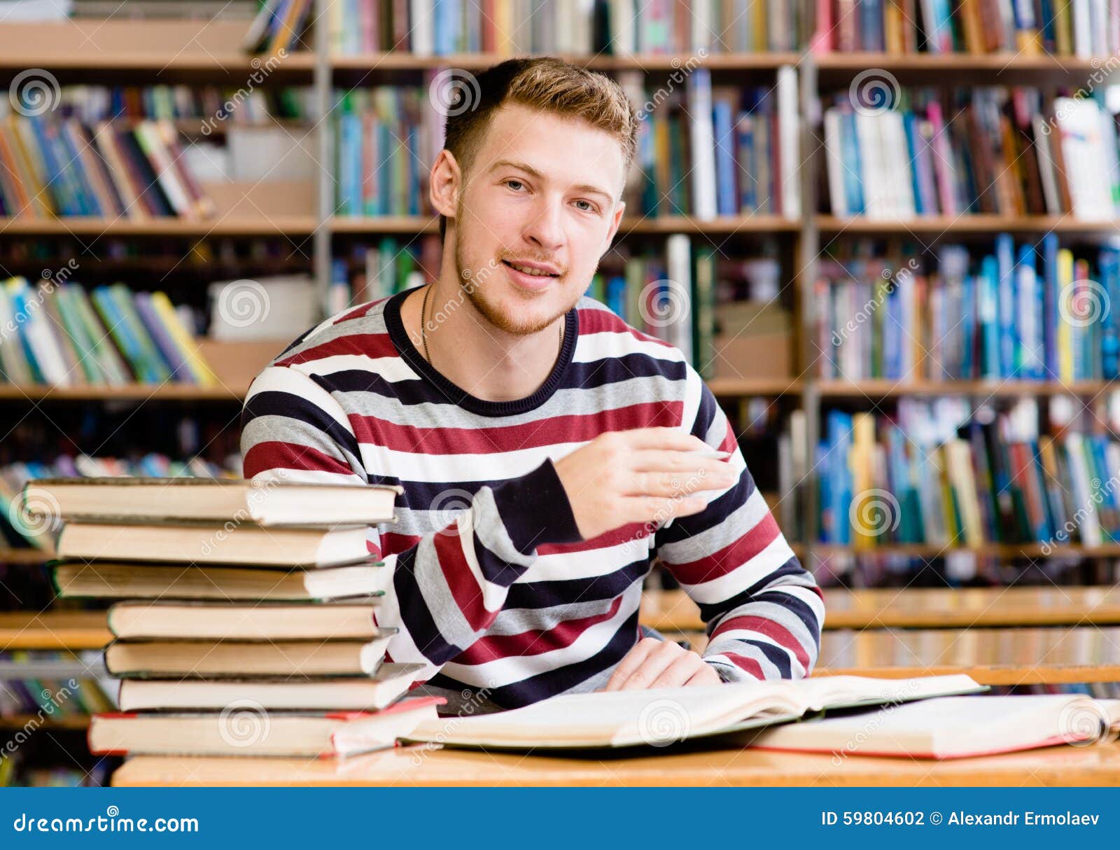 Smiling Male Student with Open Book Working in a Library Stock Photo ...