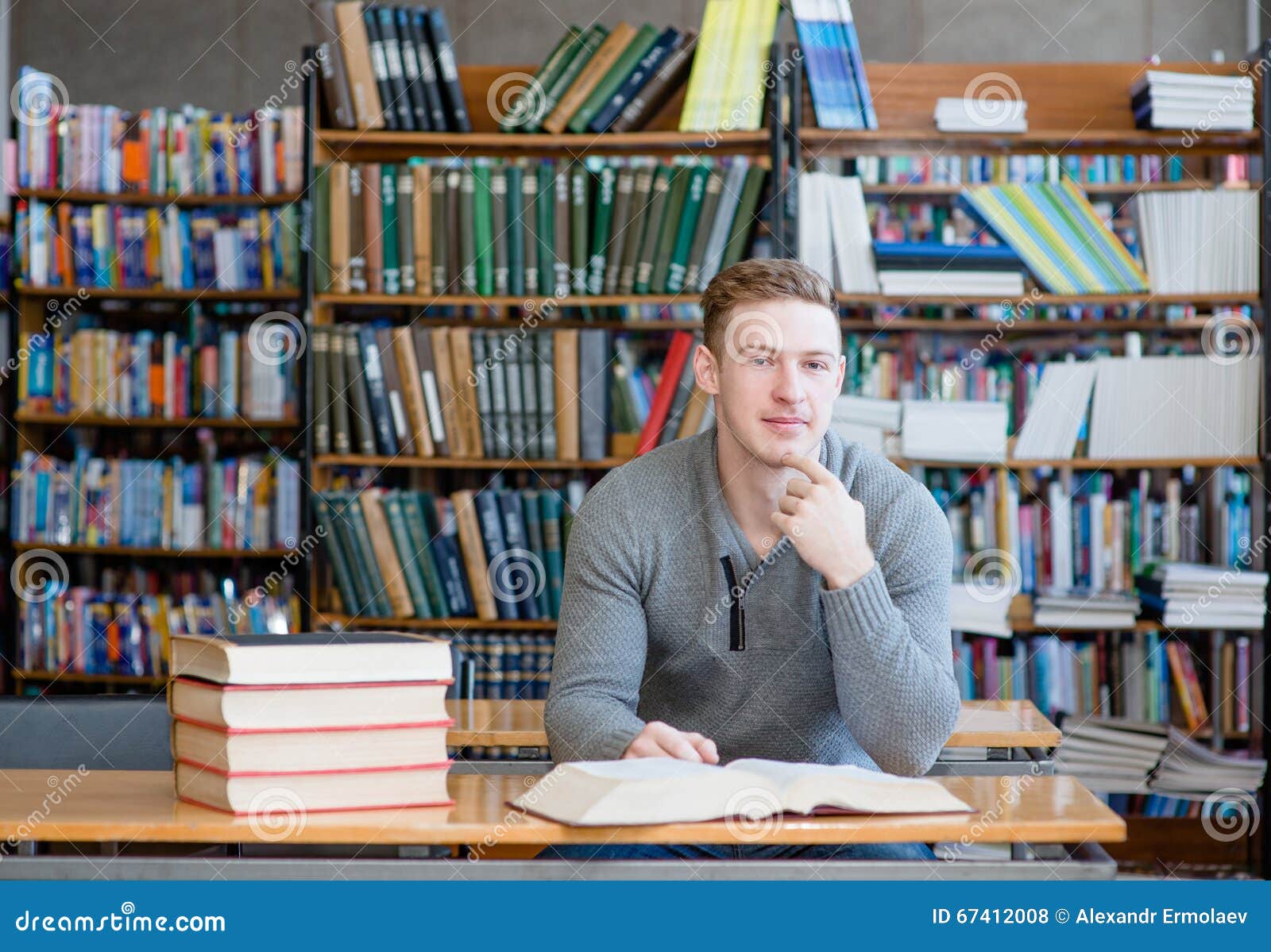 Smiling Male Student with Open Book Working in a Library Stock Photo ...
