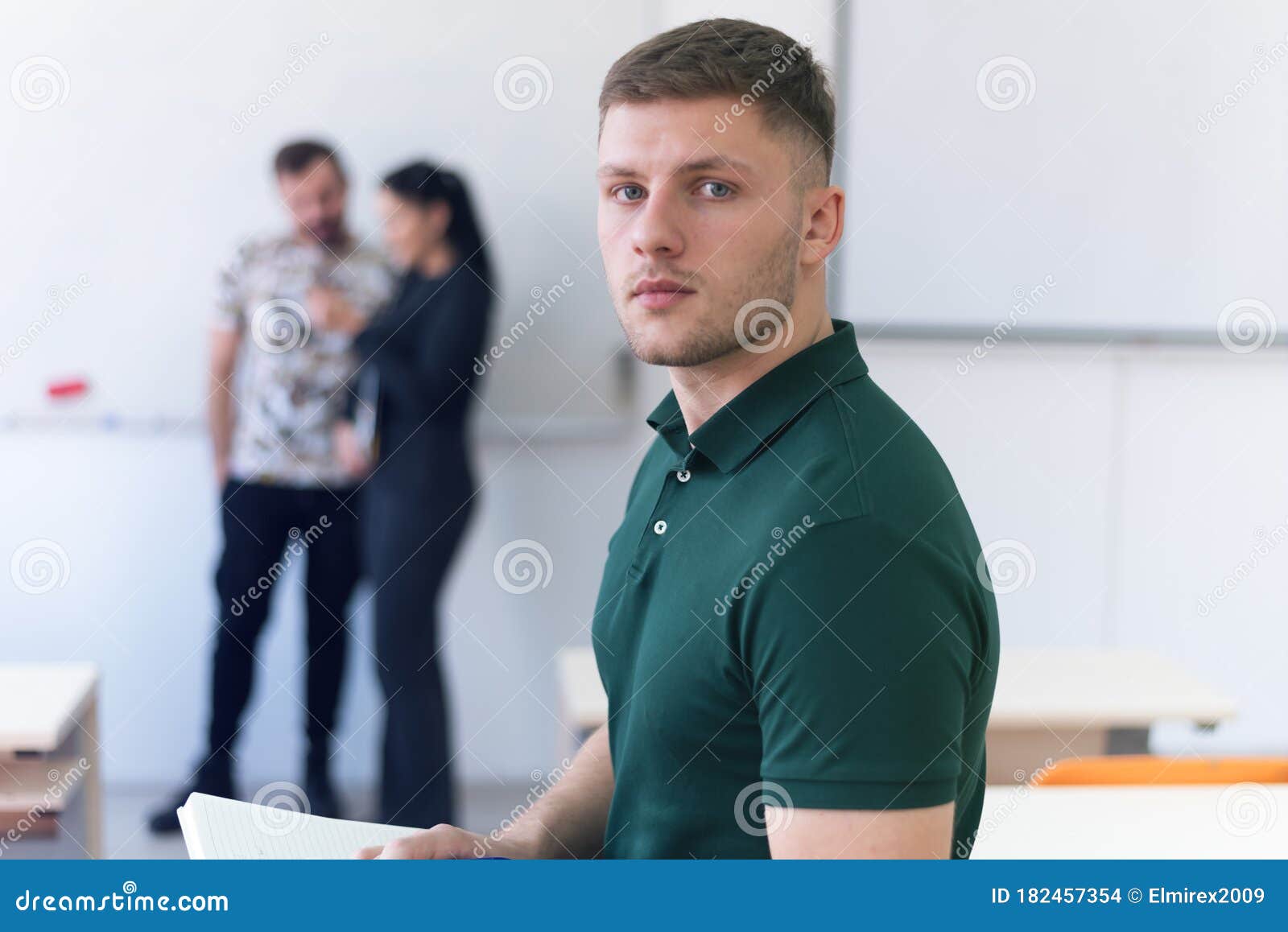 Smiling Male Student Standing in Classroom and Looking at Camera ...