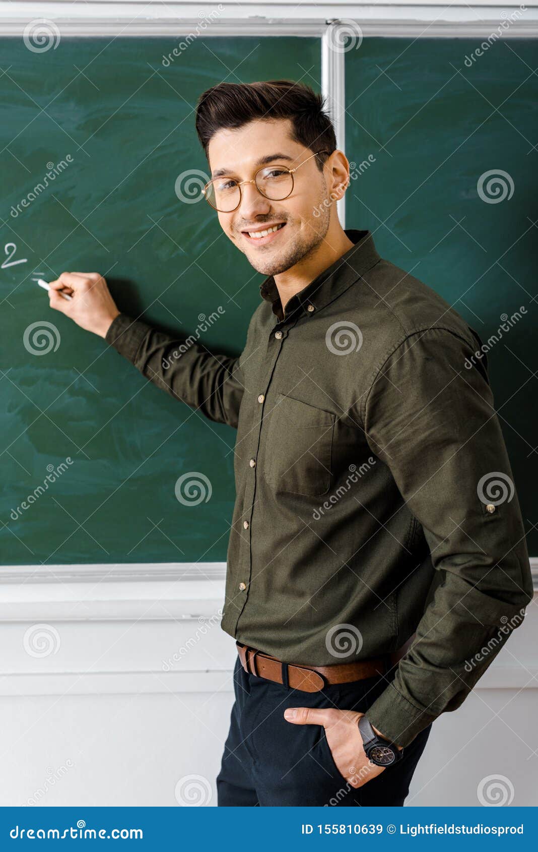 Smiling Male Teacher Looking at Camera and Writing on Chalkboard Stock ... Smiling Male Teacher Looking at Camera and Writing on Chalkboard Stock ...