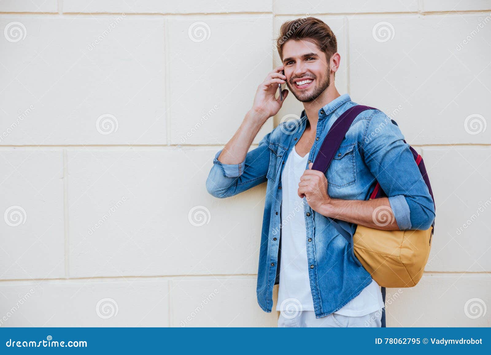 Smiling Man with Backpack Standing and Talking on Mobile Phone Stock ...