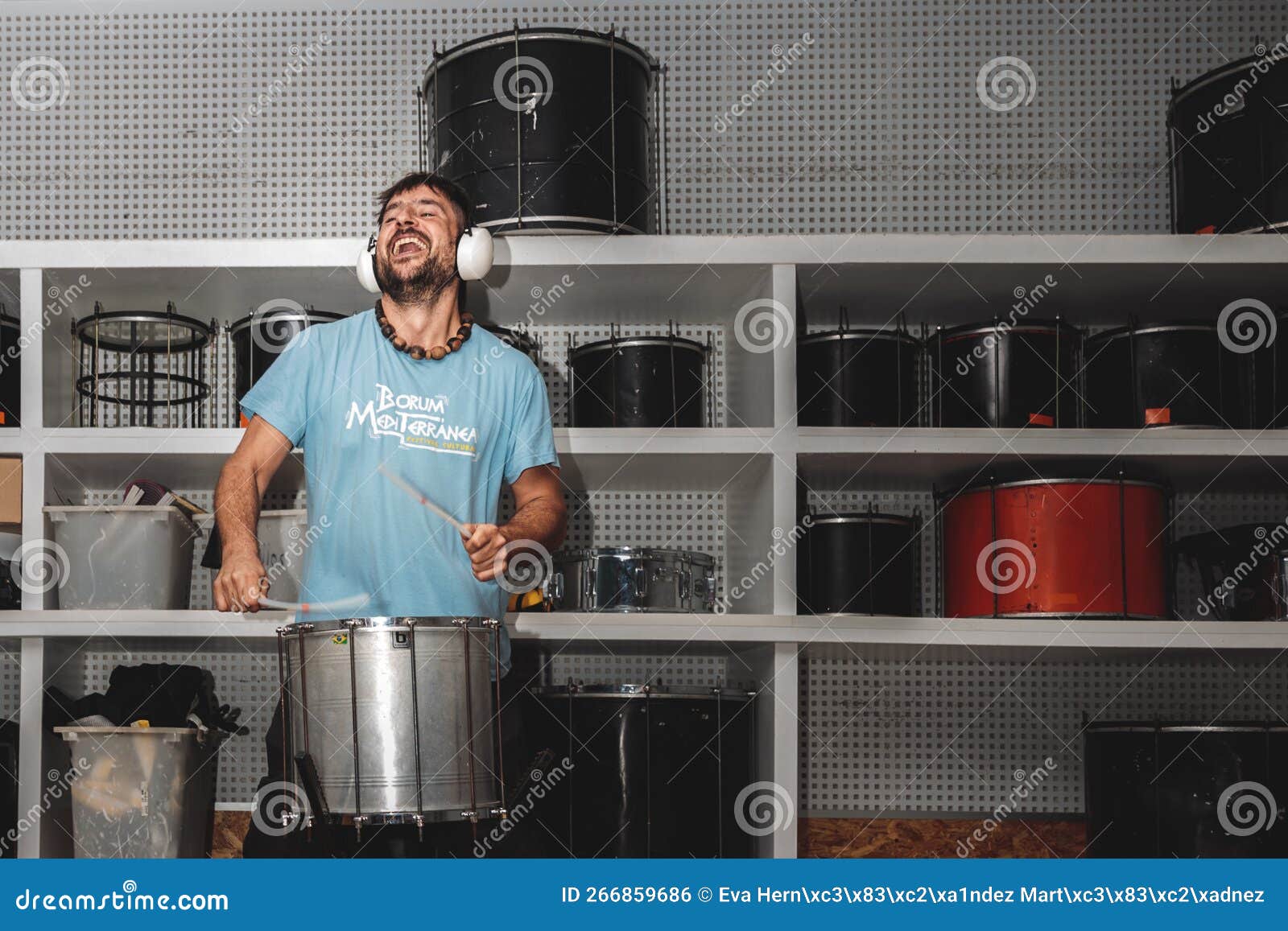 A Smiling Man Beating a Drum with Drumsticks Stock Photo - Image of ...