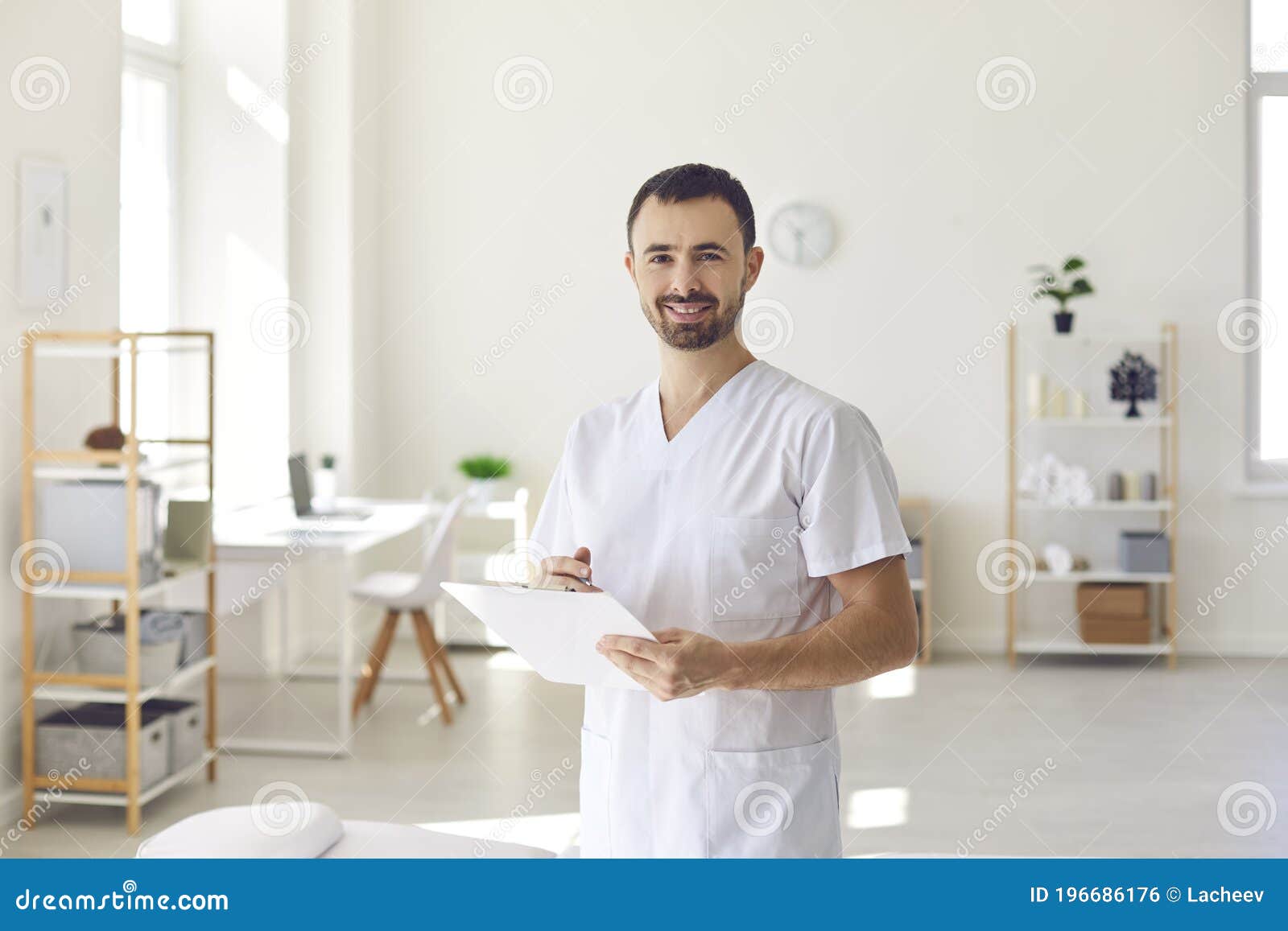 Smiling Man Doctor Chiropractor or Osteopath Standing with Notes and ...