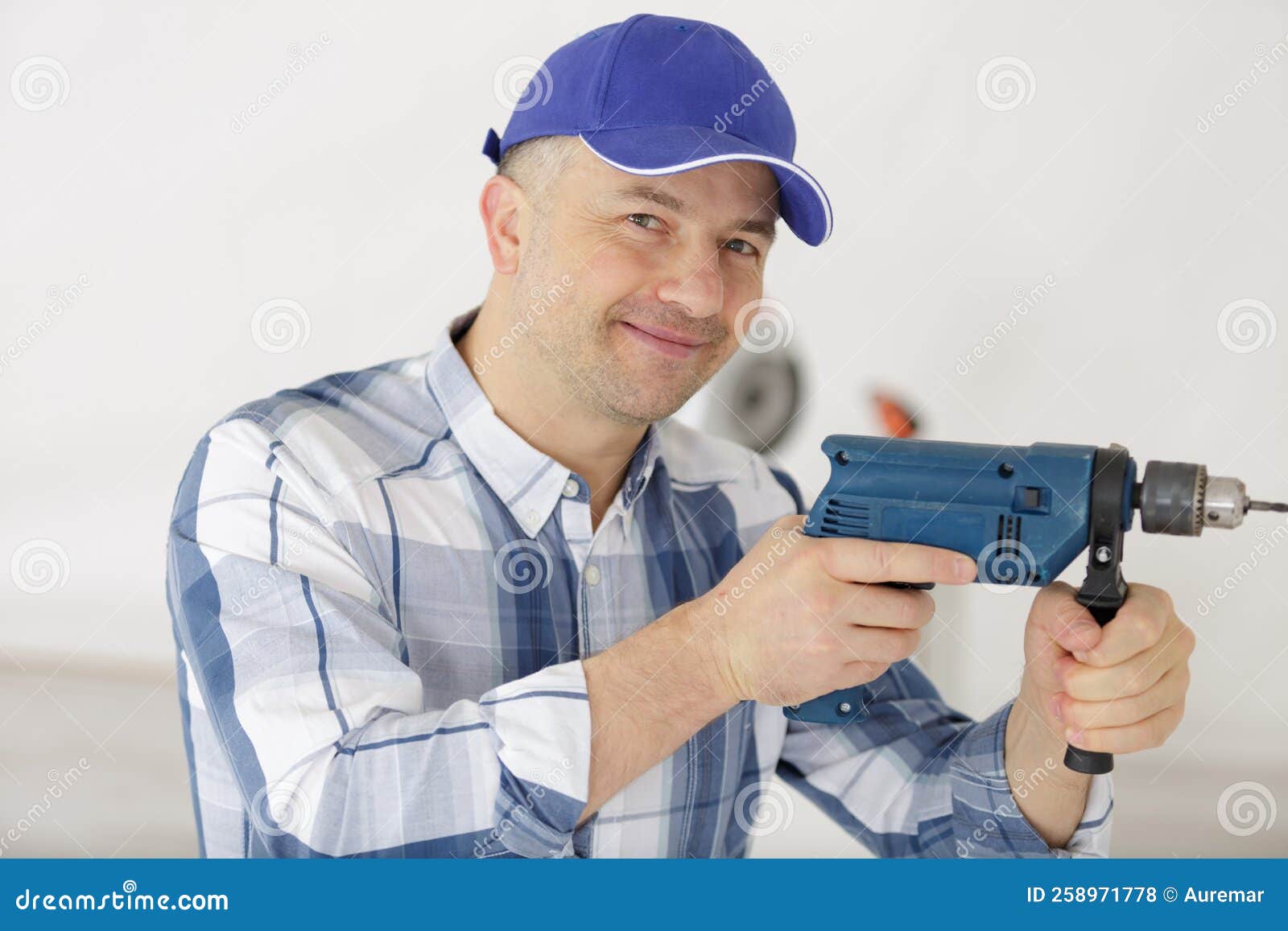 Smiling Man with Electric Drill Making Hole in Wall Stock Photo - Image ...