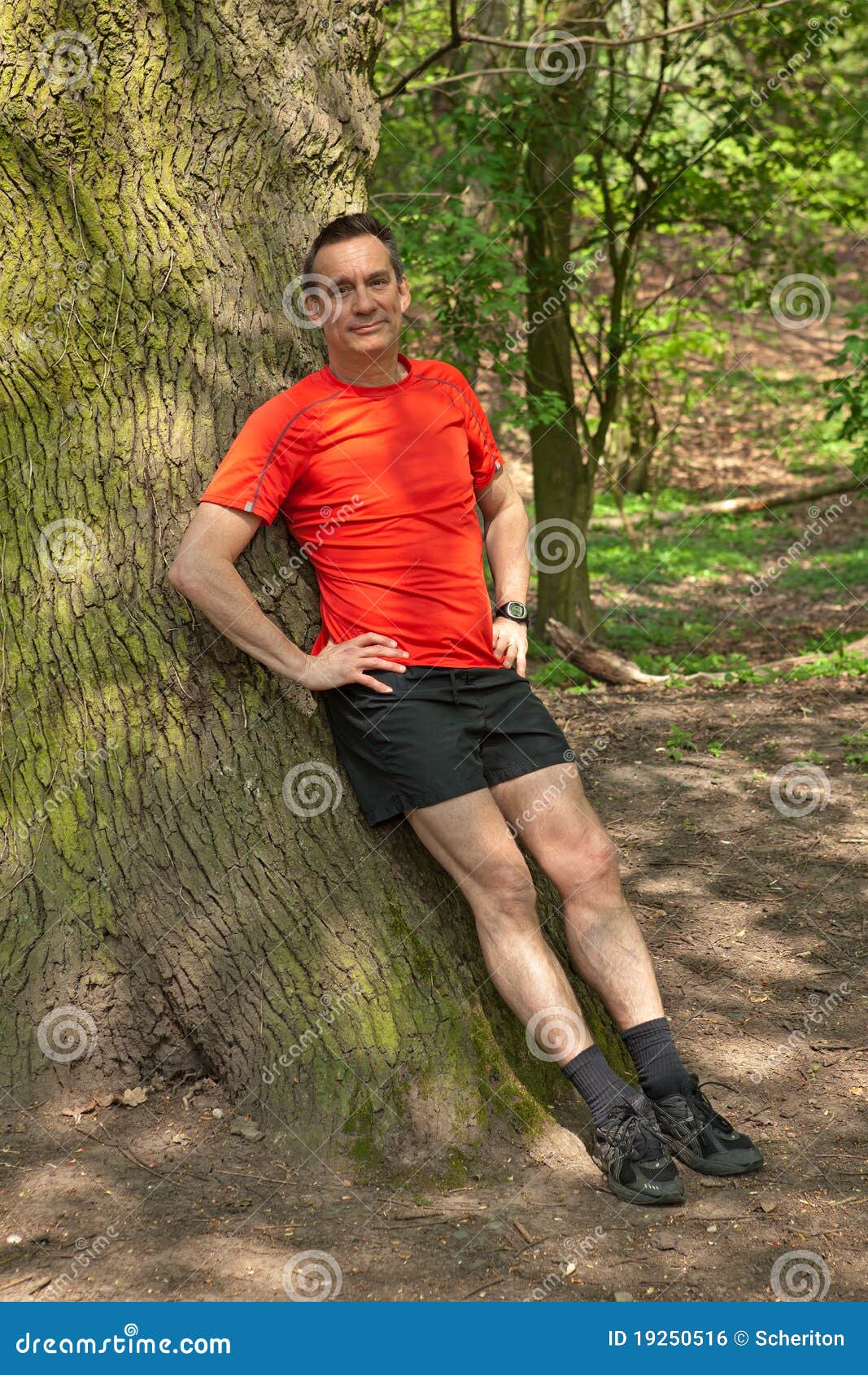 Smiling Man Exercising and Relaxing Against a Tree Stock Photo - Image ...