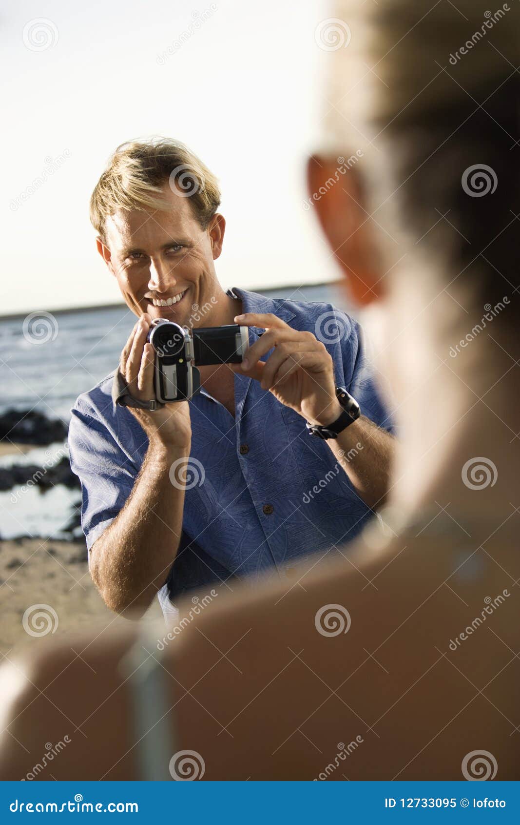 Smiling Man Filming Woman at Beach Stock Image - Image of cropped ...