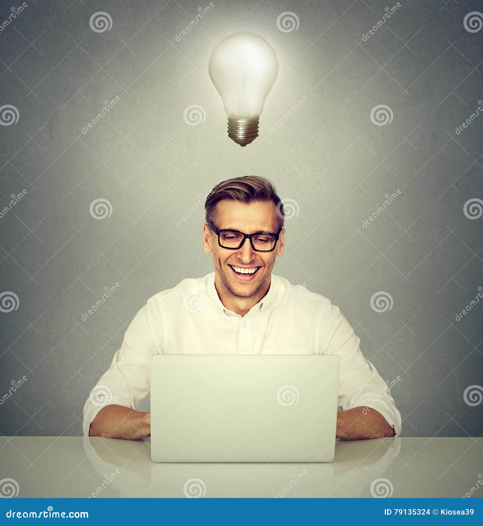 Smiling Man in Front of Computer with Light Bulb Over Head Stock Photo ...