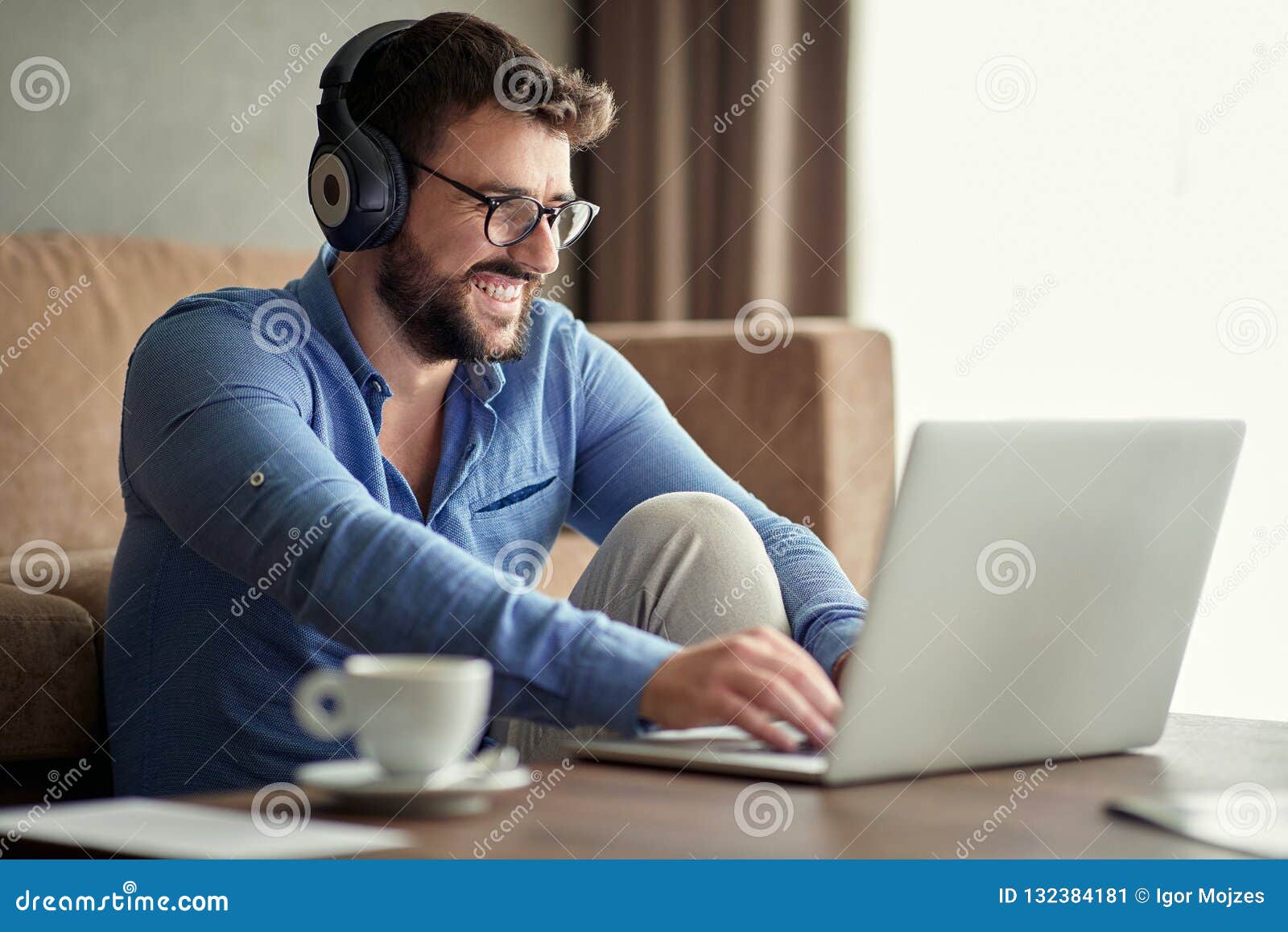 Smiling Man with Headphones Using Laptop in His Home Stock Image ...