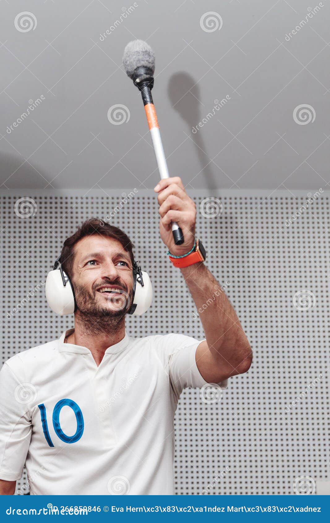 A Smiling Man Holding a Mace with Protection in His Ears Stock Photo ...