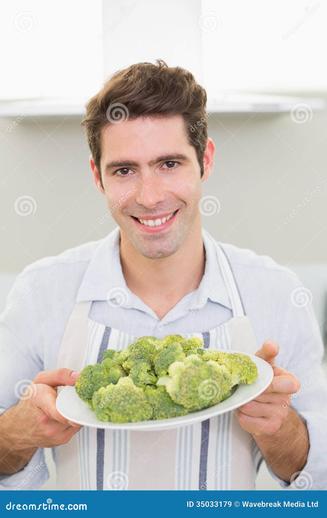 Smiling Man Holding a Plate of Broccoli in Kitchen Stock Image - Image ...