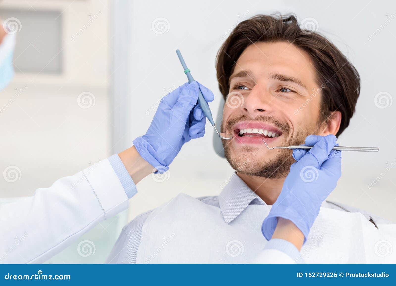 Smiling Man Looking at Dentist with Trust Stock Photo - Image of glove ...
