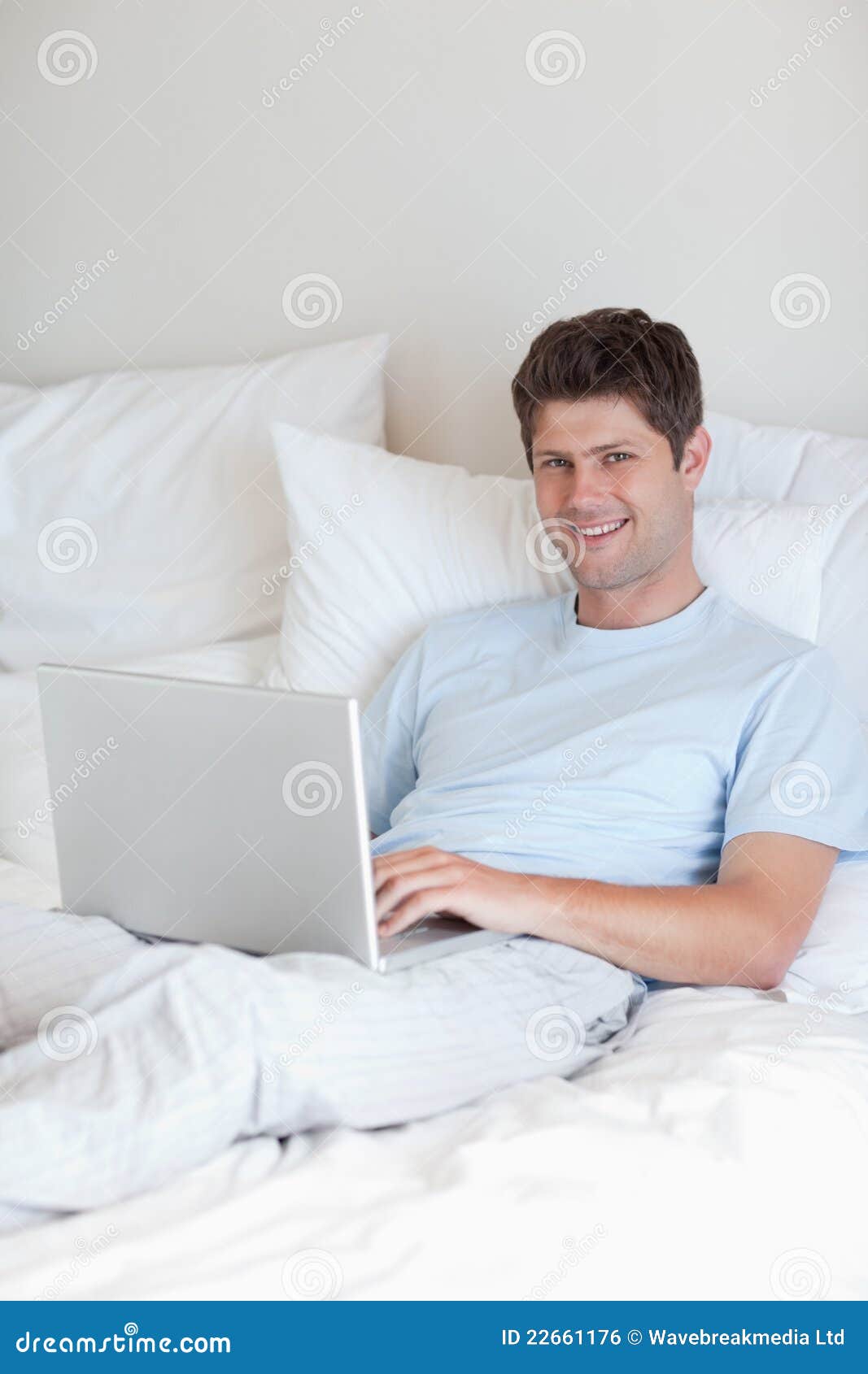 Smiling Man Lying in Bed with Notebook Stock Photo - Image of handsome ...
