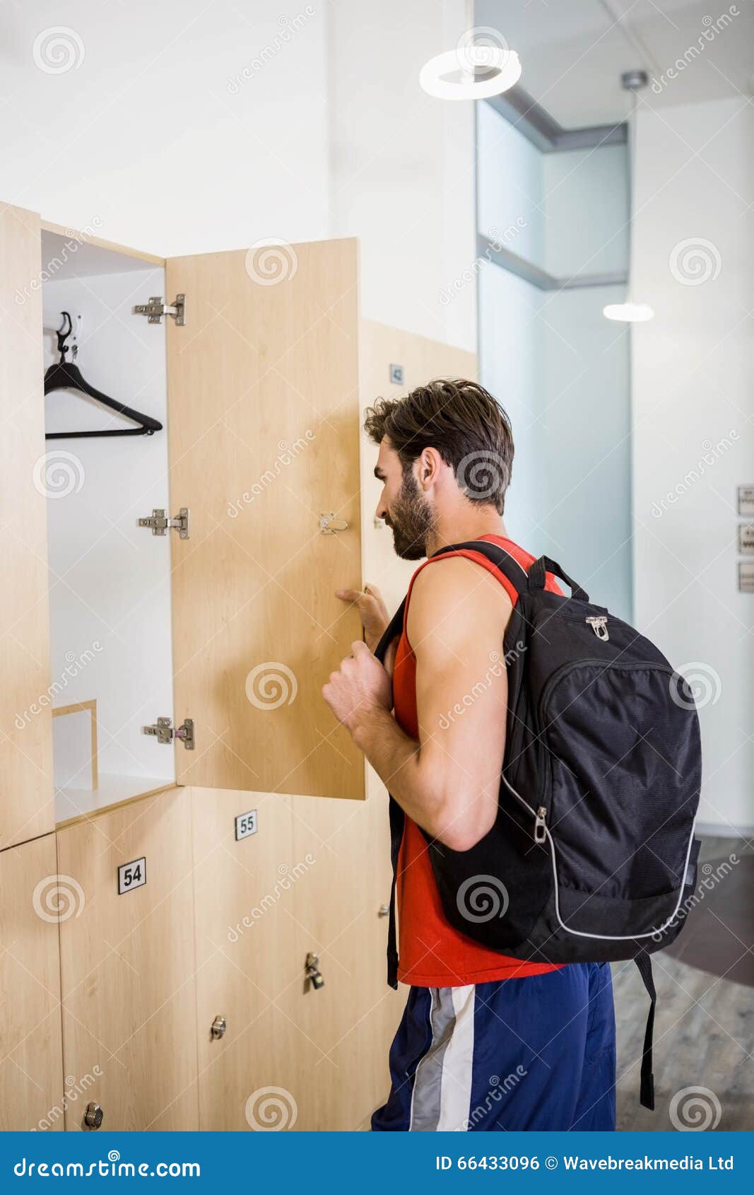 Smiling man opening locker stock photo. Image of incline - 66433096