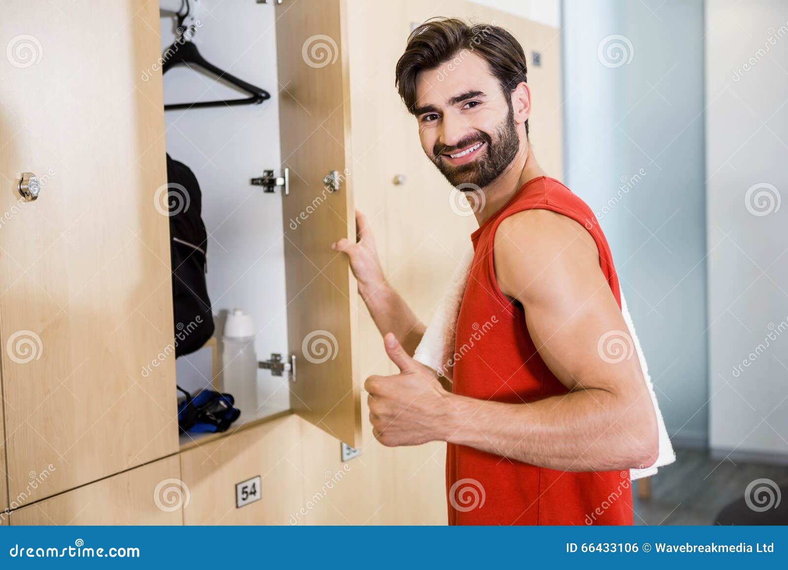 Smiling man opening locker stock photo. Image of activity - 66433106