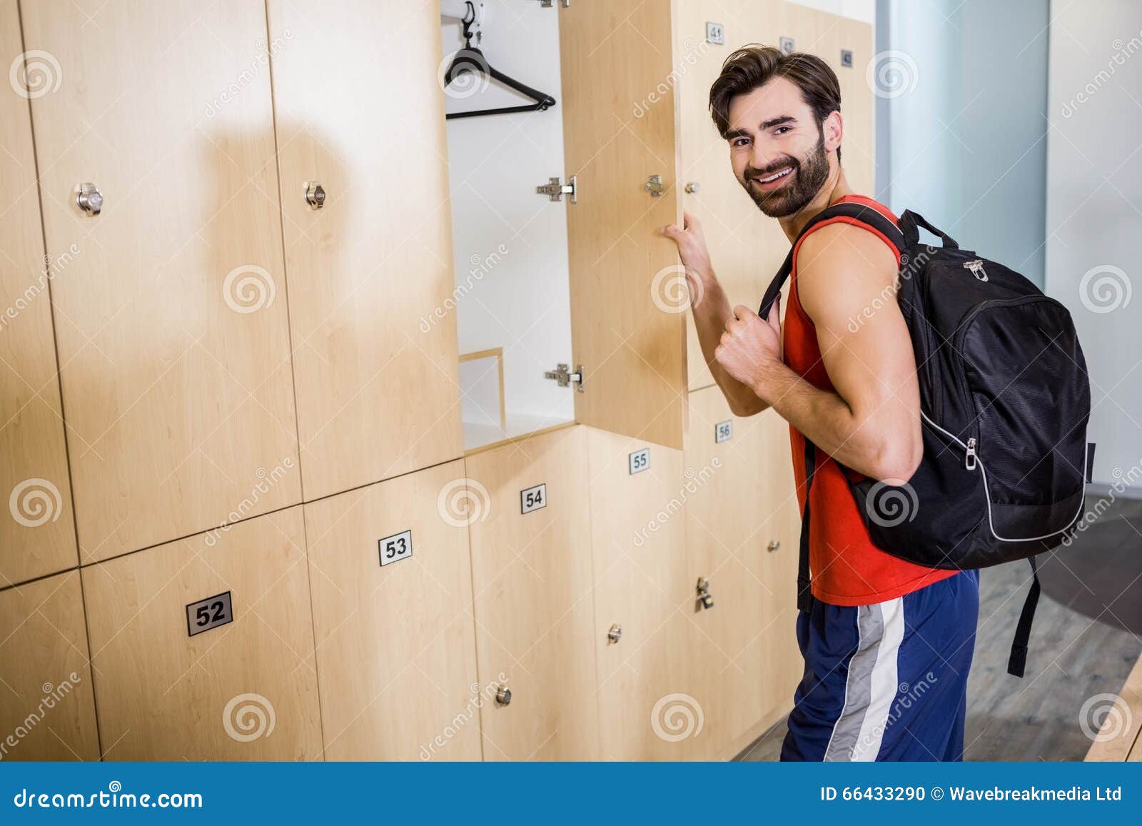 Smiling man opening locker stock photo. Image of effort - 66433290