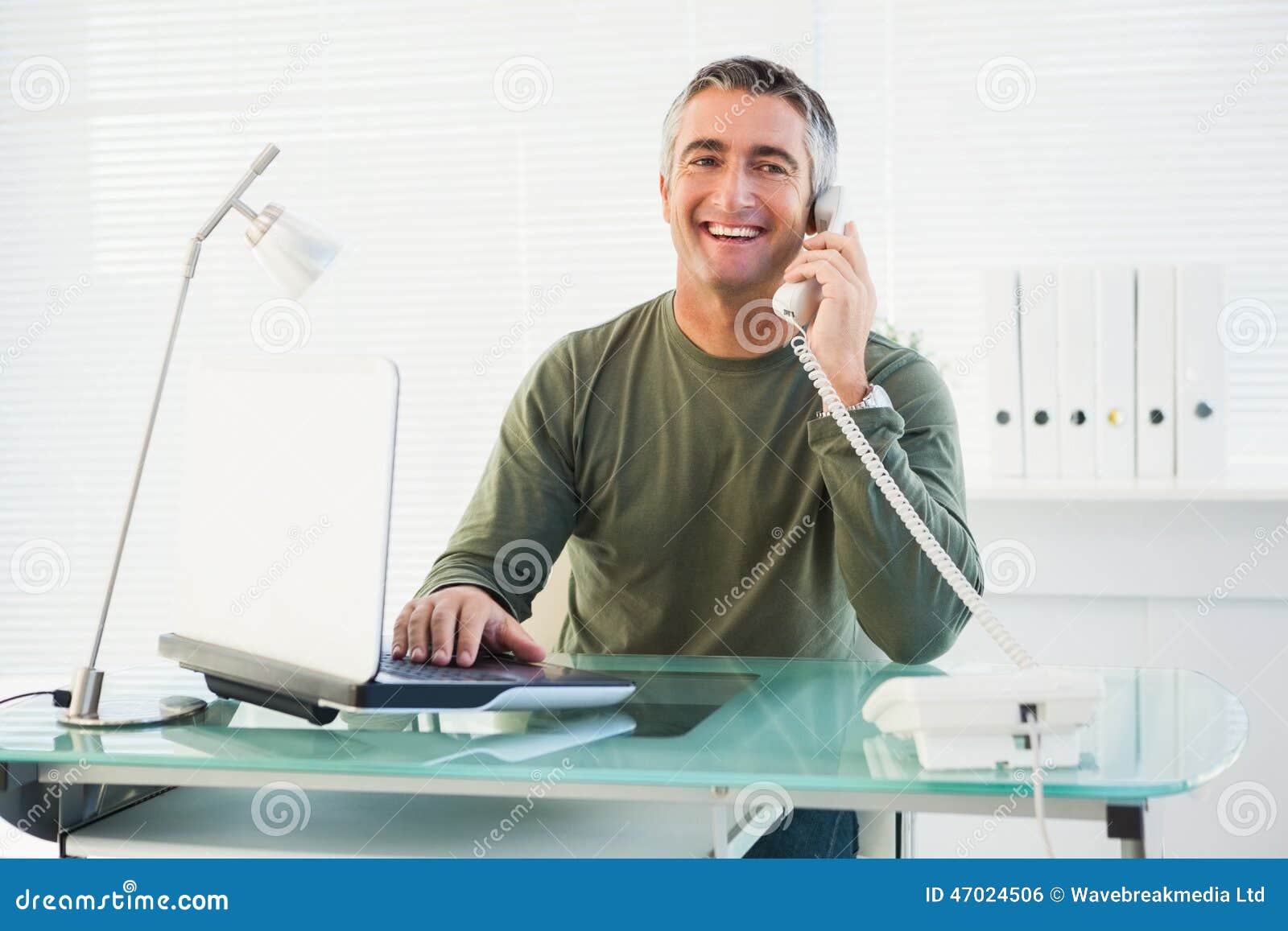 Smiling Man on the Phone Using Laptop Stock Photo - Image of typing ...
