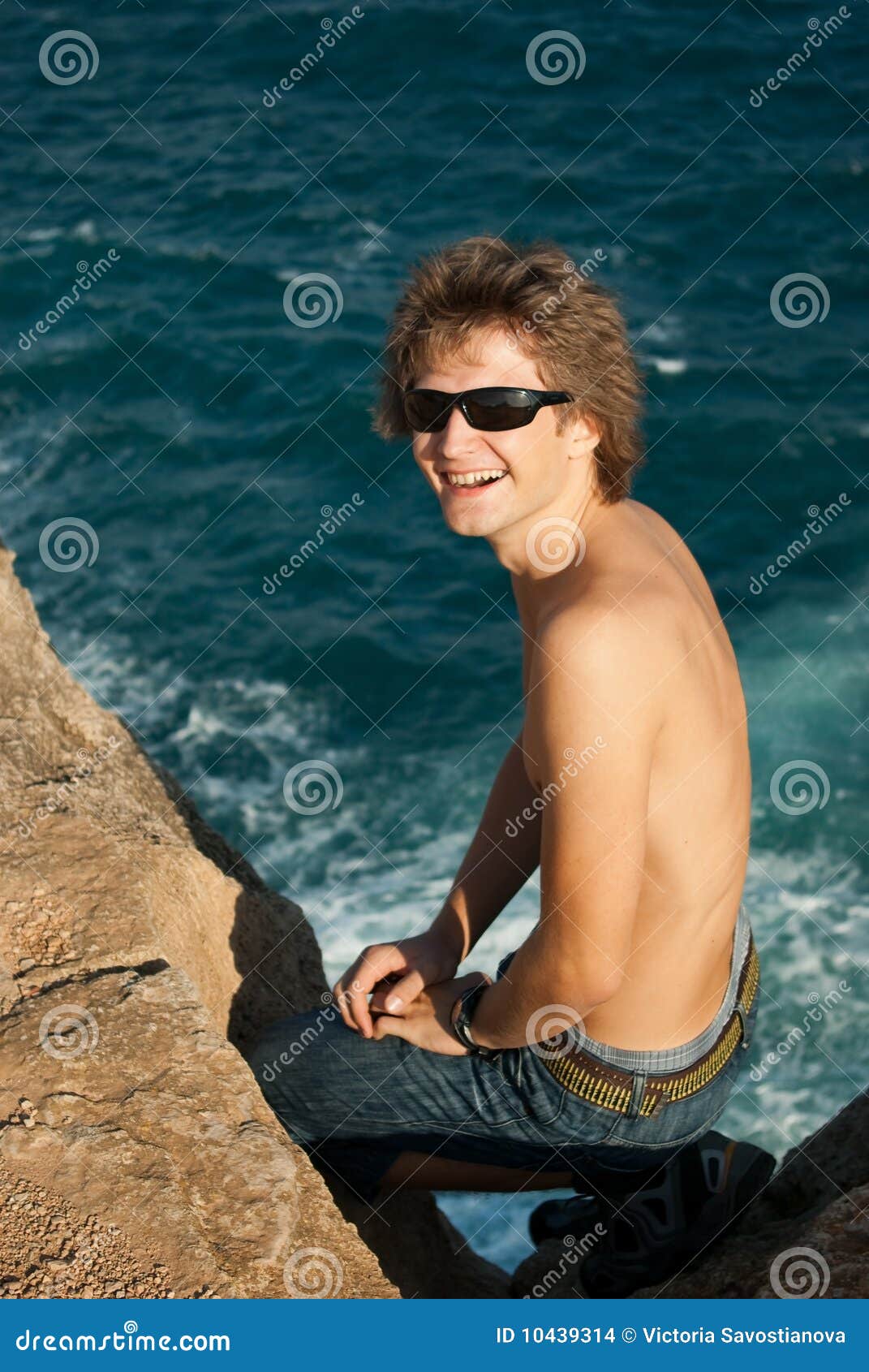 Smiling man on the rock stock photo. Image of young, water - 10439314