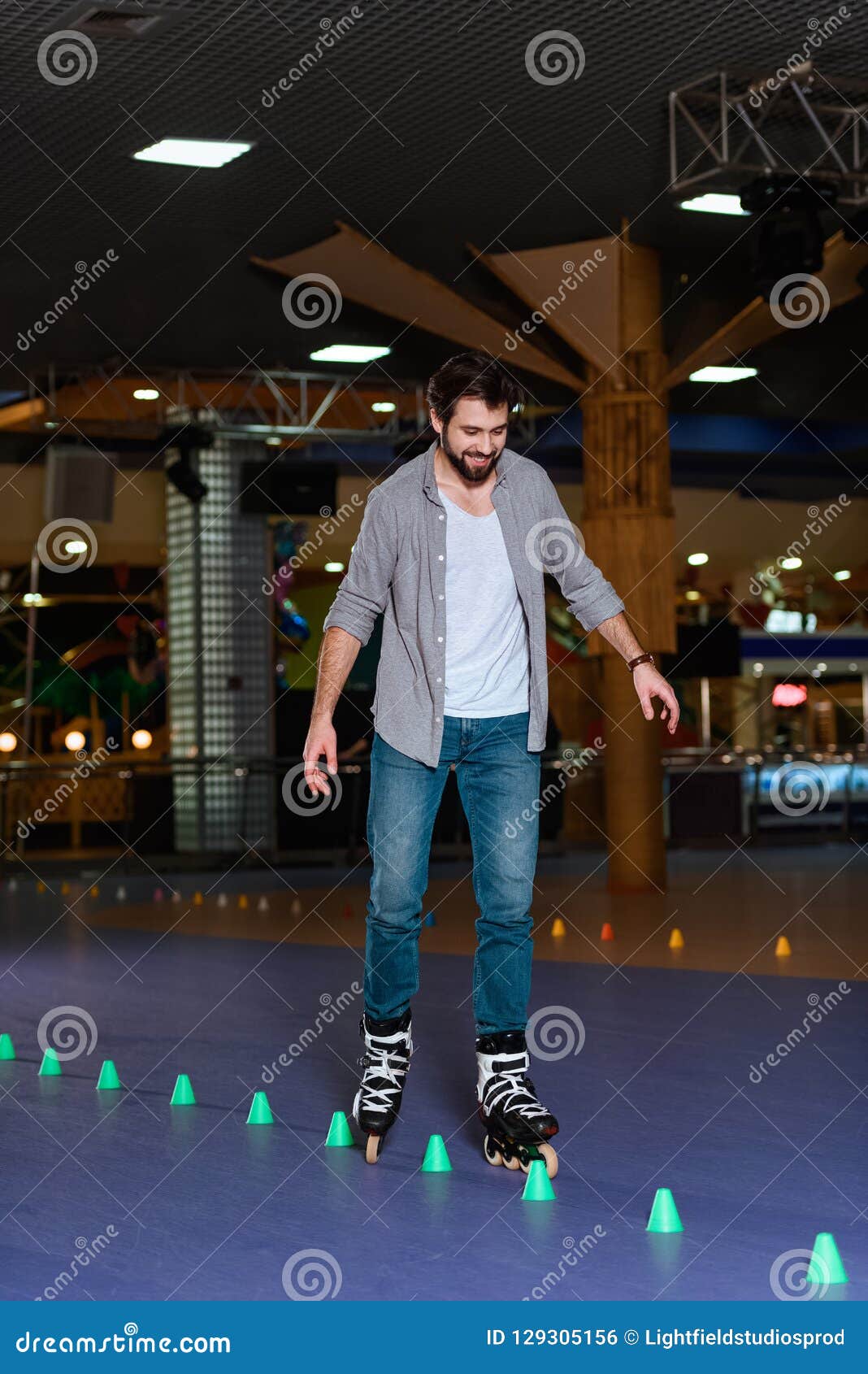 Smiling Man in Roller Skates Skating on Roller Rink Stock Photo - Image ...