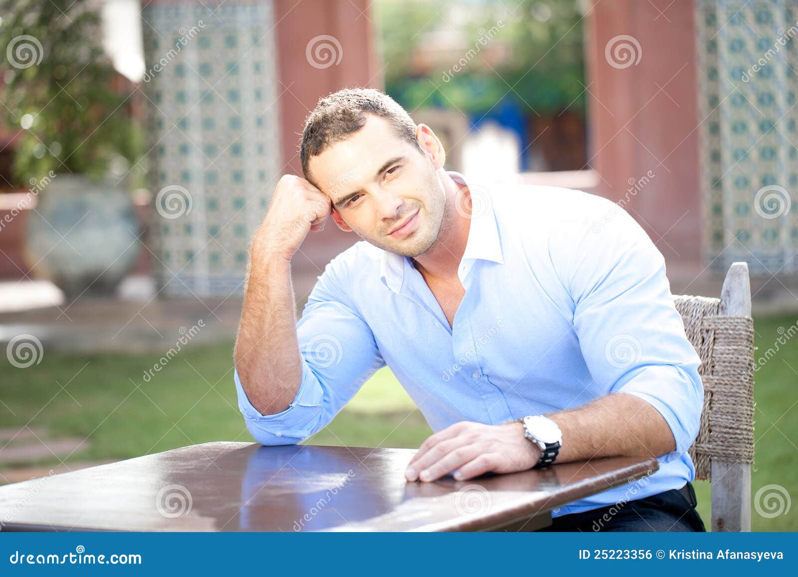 Smiling Man Seated at a Table Outdoors Stock Photo - Image of person ...
