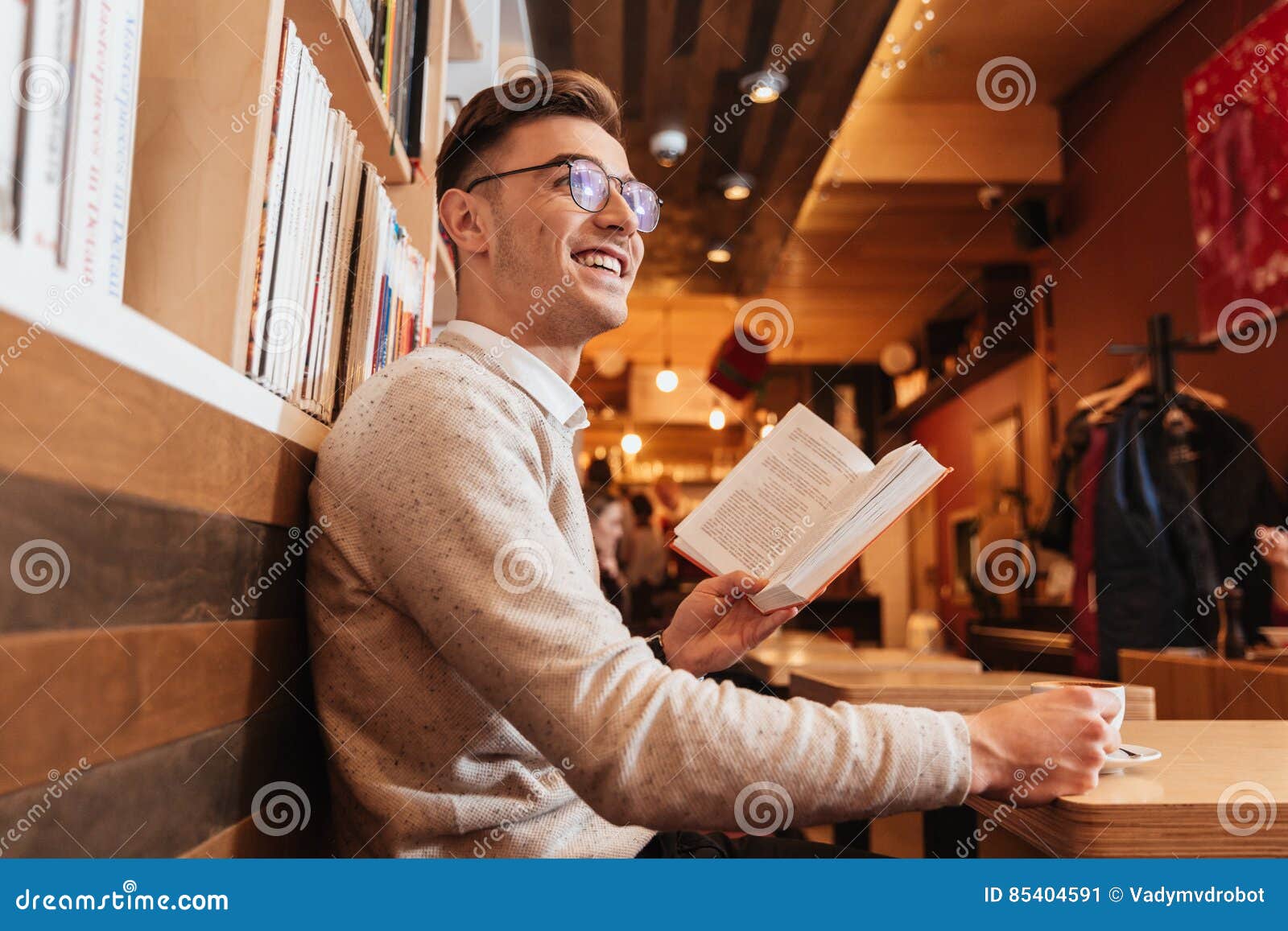 Smiling Man Sitting in Cafe while Reading Book Stock Image - Image of ...
