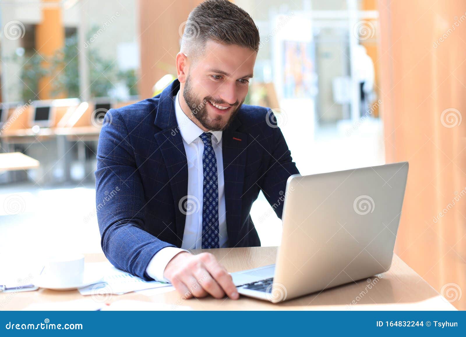 Smiling Man Sitting in Office and Using His Laptop Stock Photo - Image ...