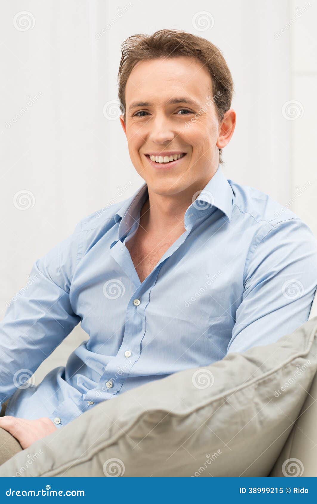 Smiling Man Sitting on Sofa Stock Image - Image of home, looking: 38999215