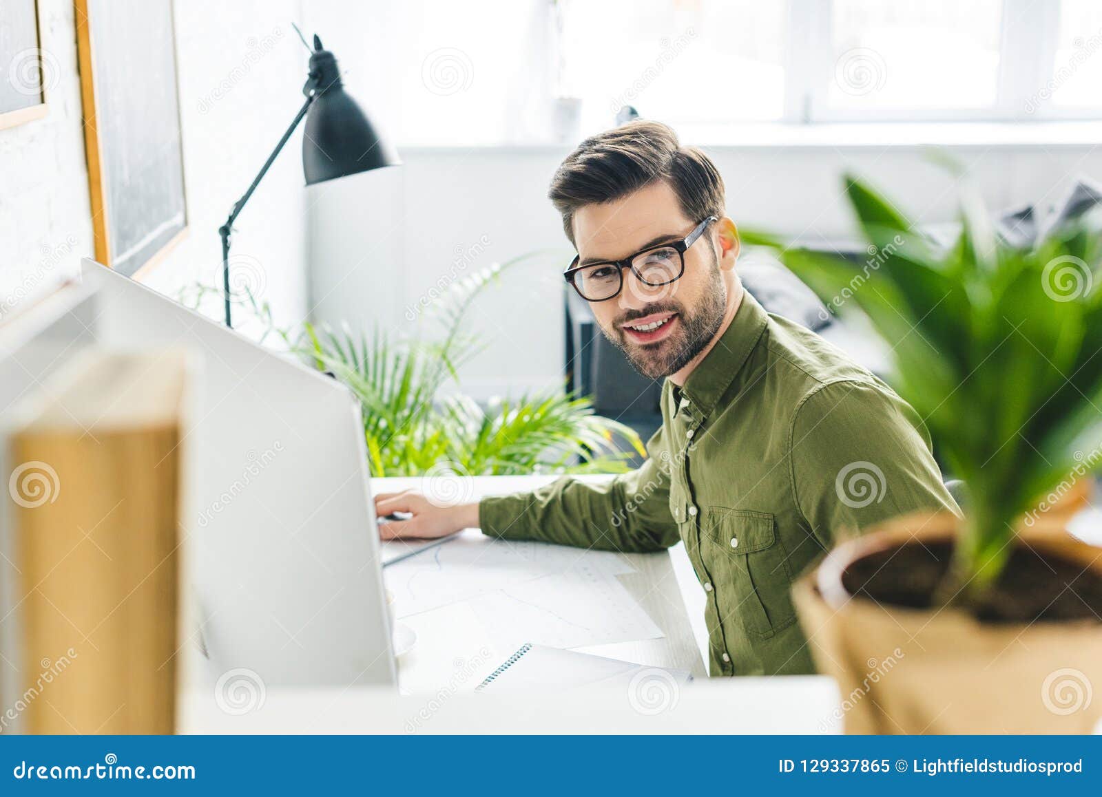 Smiling Man Sitting by Table with Computer Stock Image - Image of ...