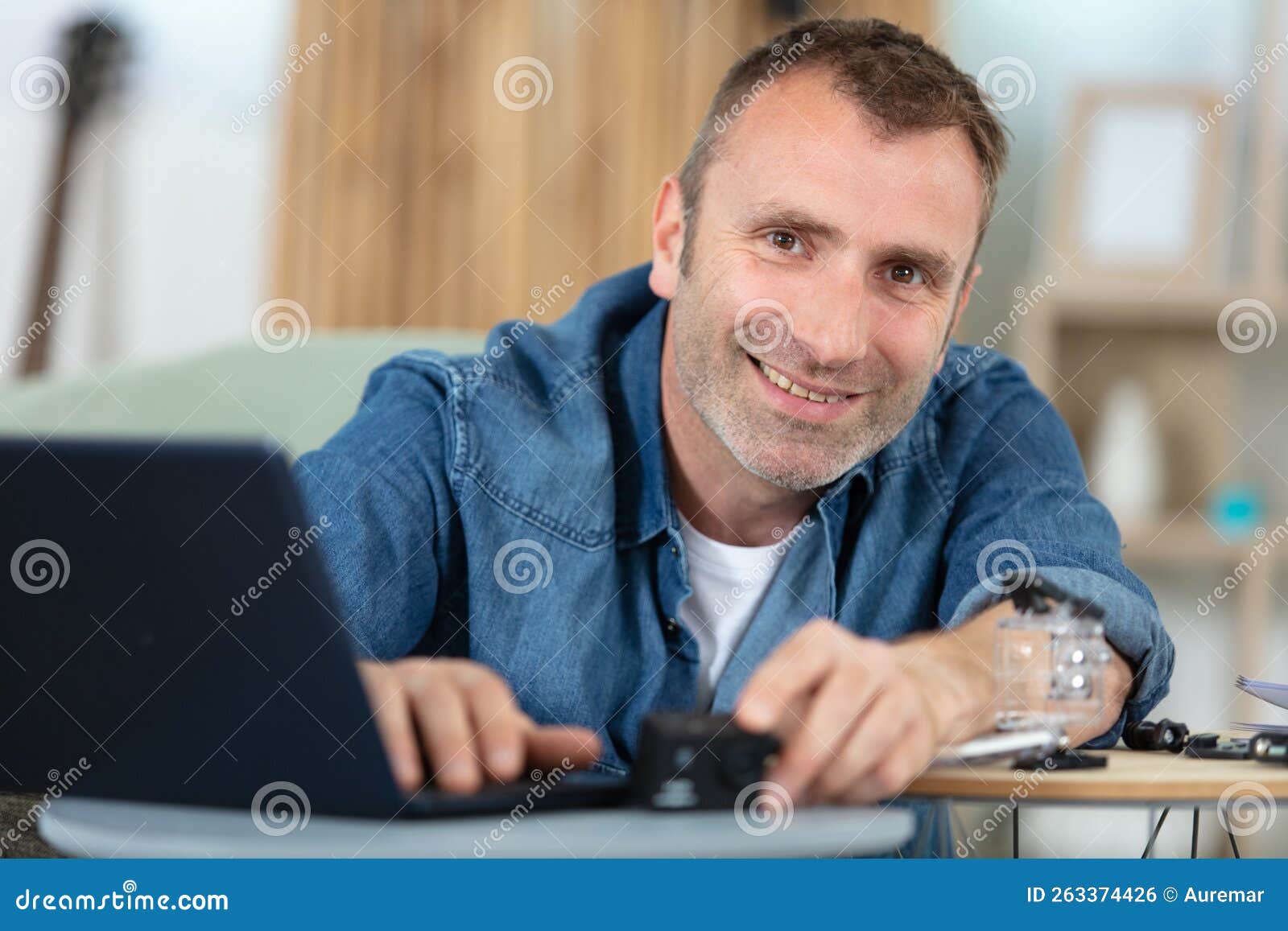 Smiling Man Sitting at Table Using Laptop Stock Photo - Image of ...