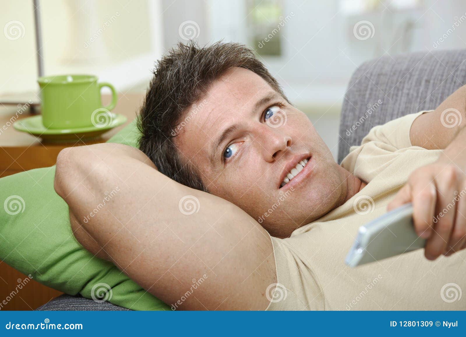Guy Using Remote Control While Sitting On The Bed In Home. Happy ...