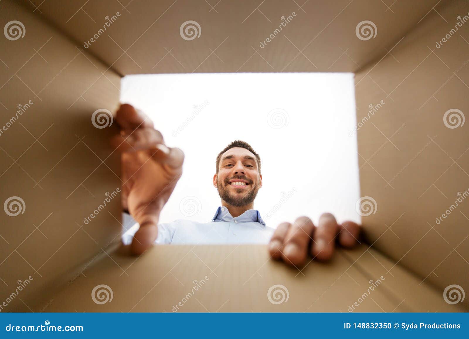 Smiling Man Taking Something Out of Parcel Box Stock Photo - Image of ...