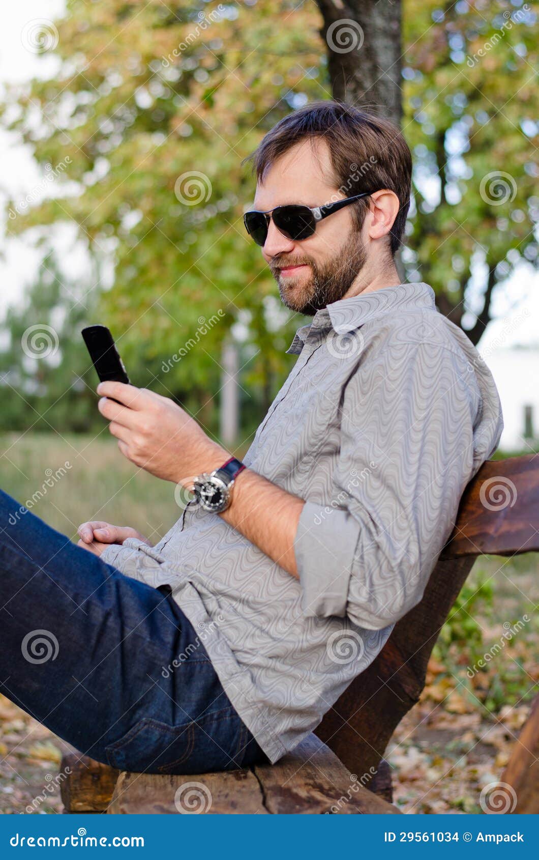 Smiling man texting stock photo. Image of bench, reading - 29561034